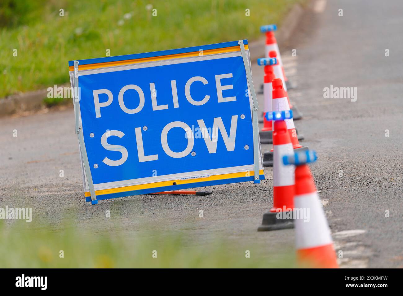 A Police Slow sign with LED lights placed on cones being used as a road ...
