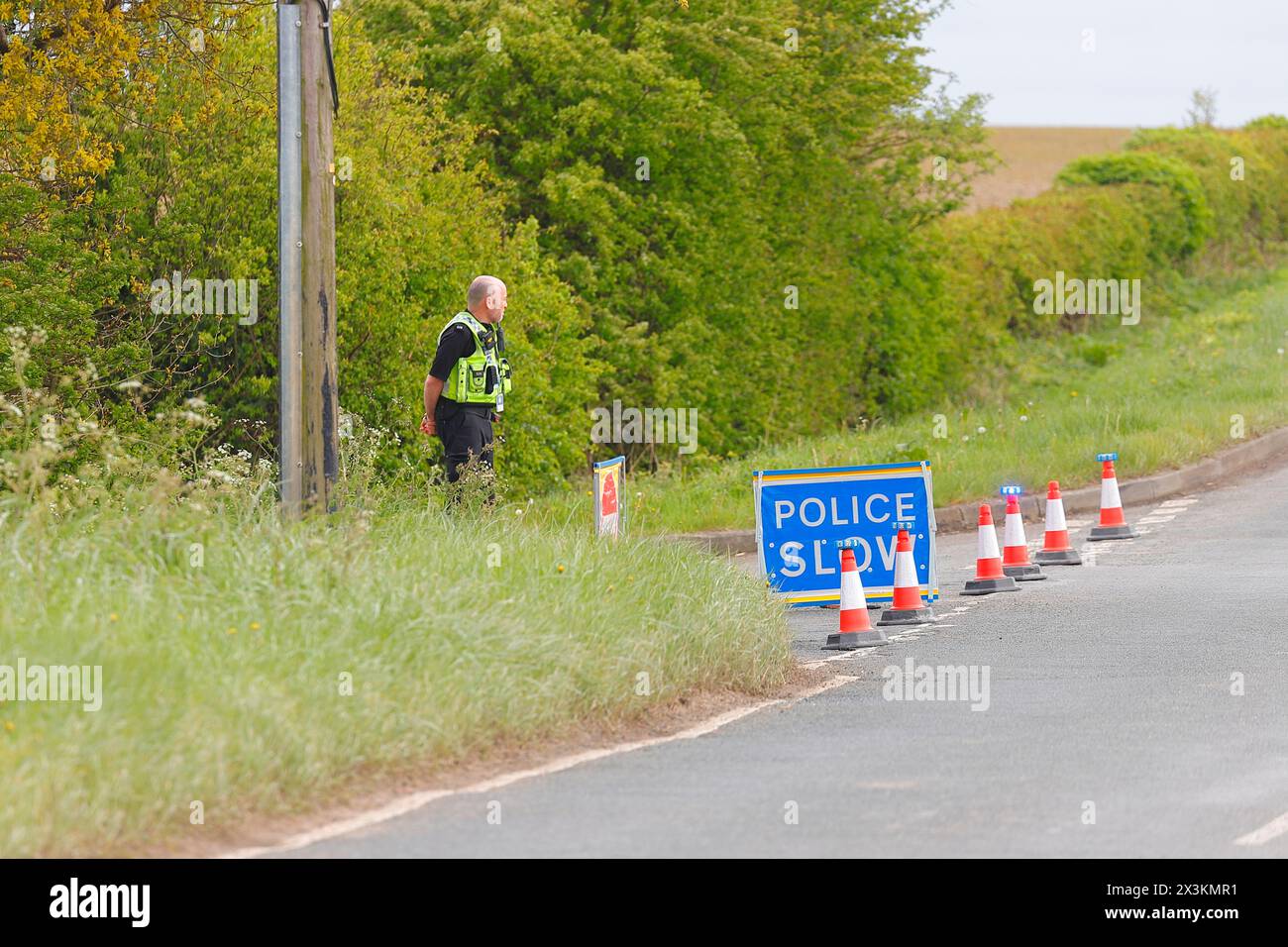 A Police Slow sign with LED lights placed on cones being used as a road ...