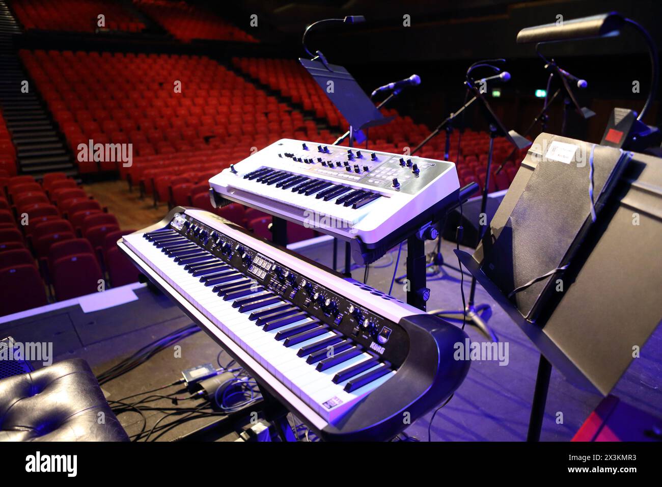Two keyboards on stage with auditorium seating behind - musician's ...