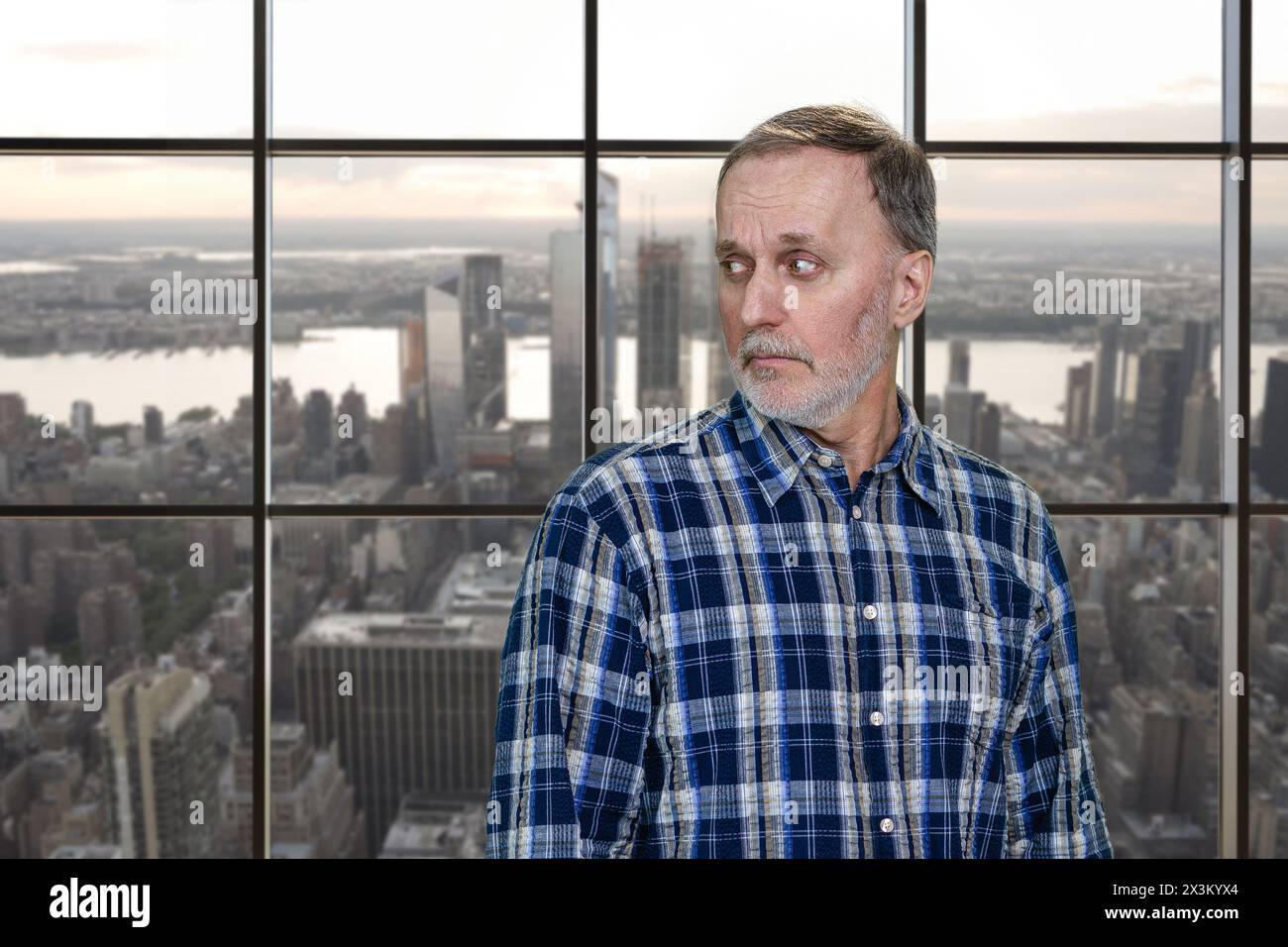 Portrait of confused aged man is looking back. Checkered window ...