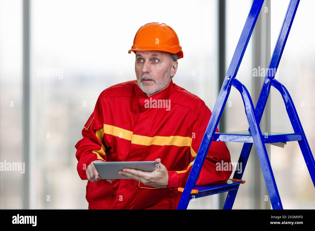 Portrait of elder caucasian contruction worker is using tablet device ...