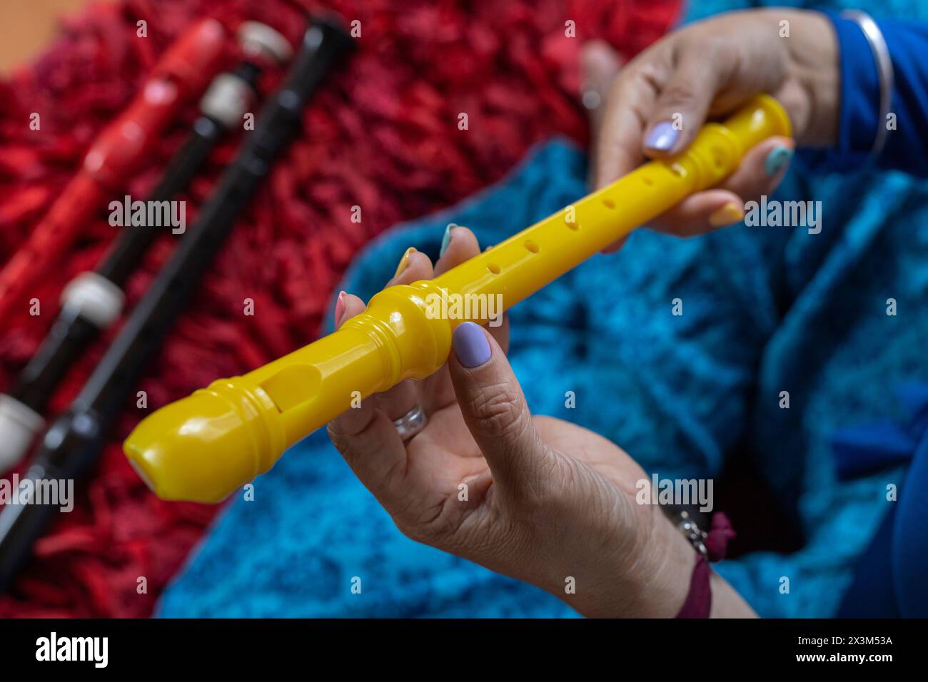 Latin American music teacher hands showing a soprano recorder ...