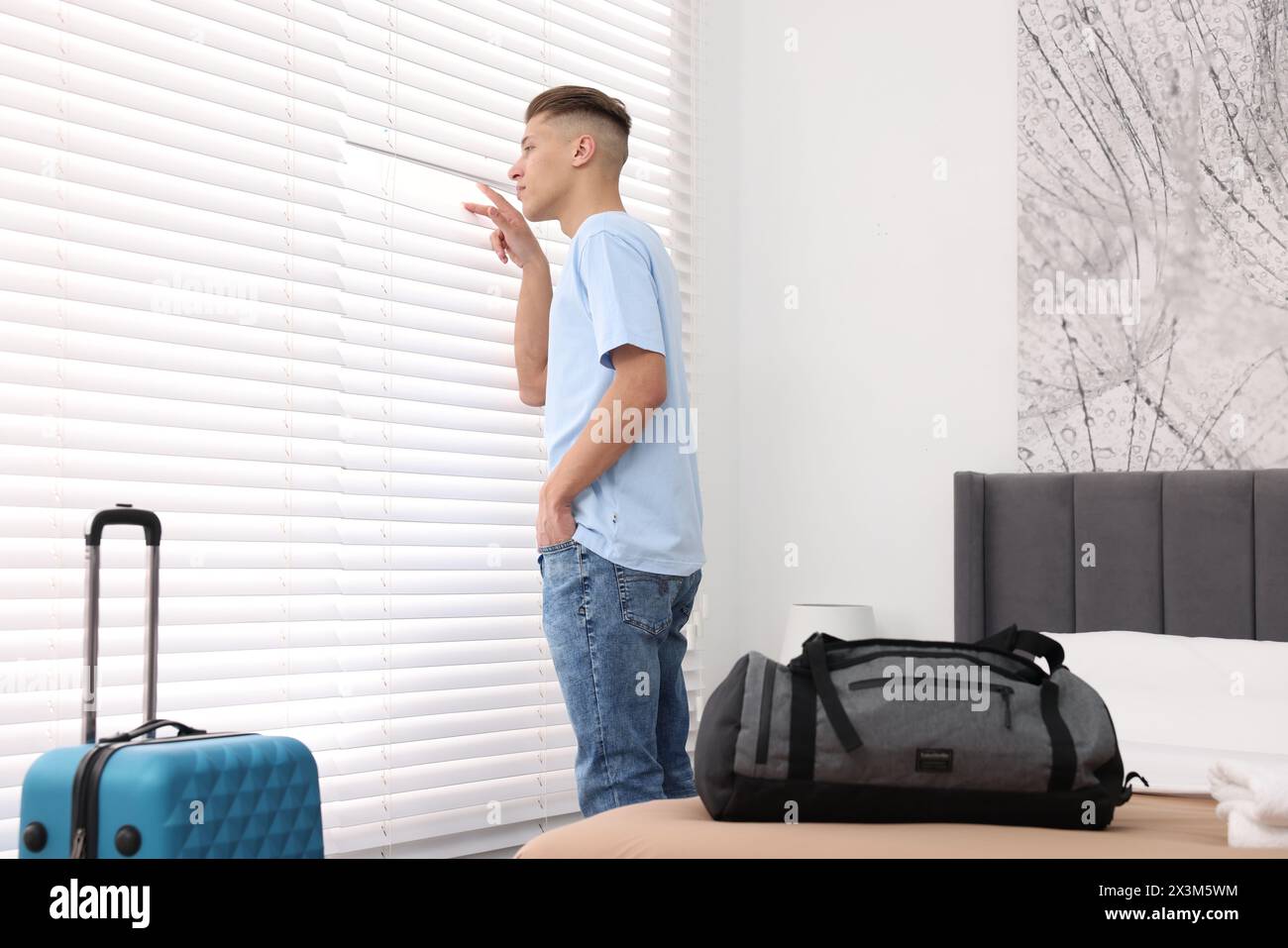 Guest looking through blinds in stylish hotel room Stock Photo - Alamy