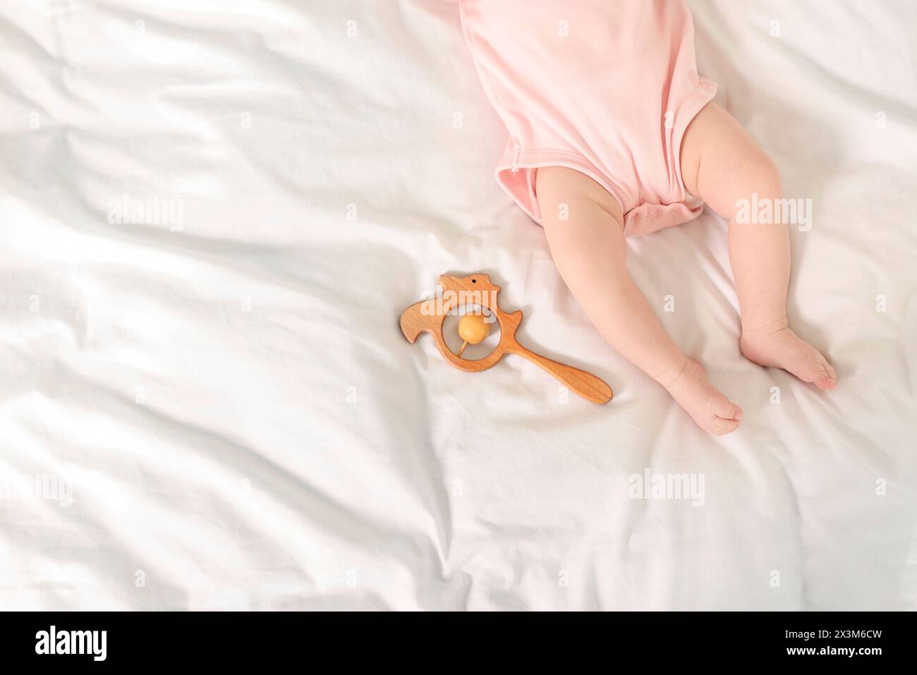Cute baby and rattle toy on sheets, top view. Space for text Stock ...