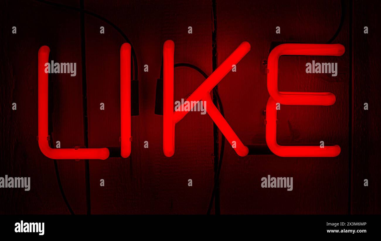Four neon letter for the word Like. Red electric light on wooden ...
