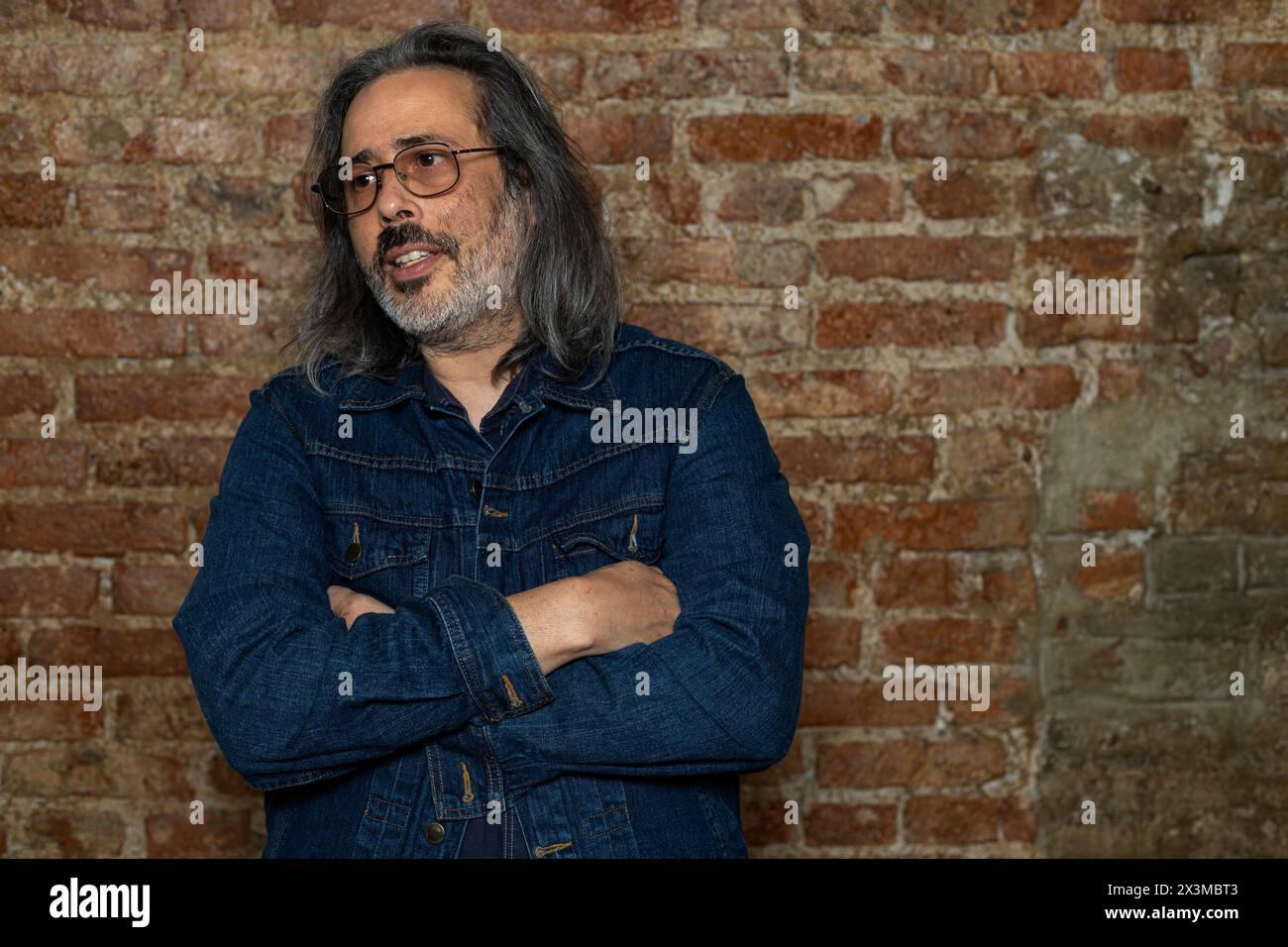 Latin American man (44) with long gray hair, blue jeans jacket and ...