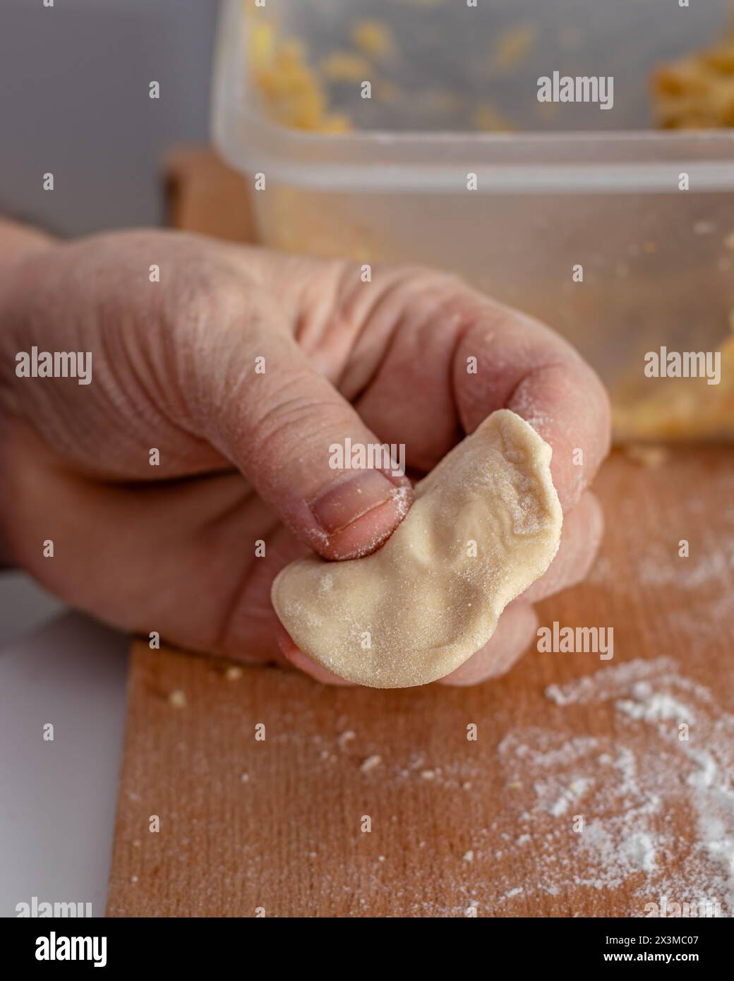 Woman hands are making a damp dumpling. On the wooden counter Stock ...