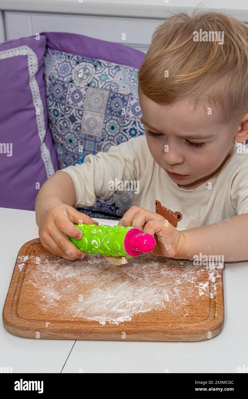 The child makes rolls the dough for dumplings.Lviv Ukraine 03.24.2024 ...