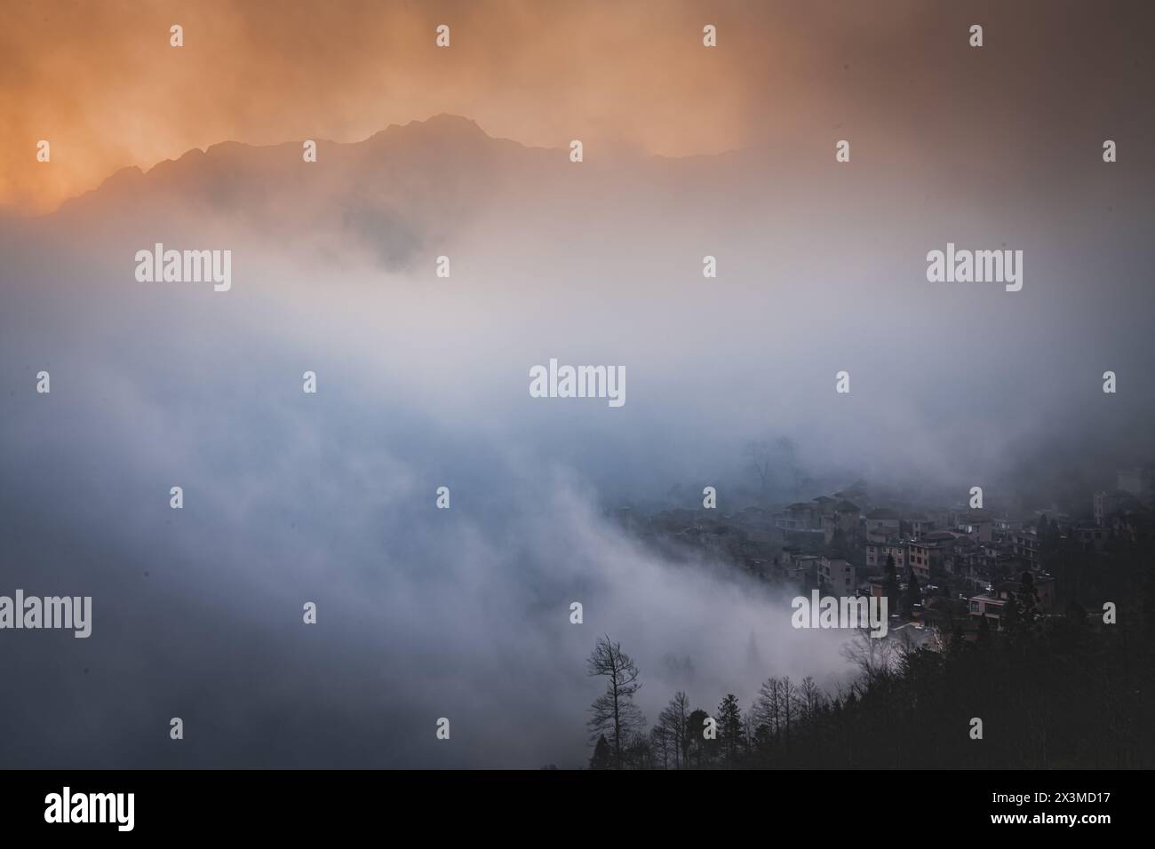Orange sunrise sky at the rice terraces, dense fog and Duoyishu village ...