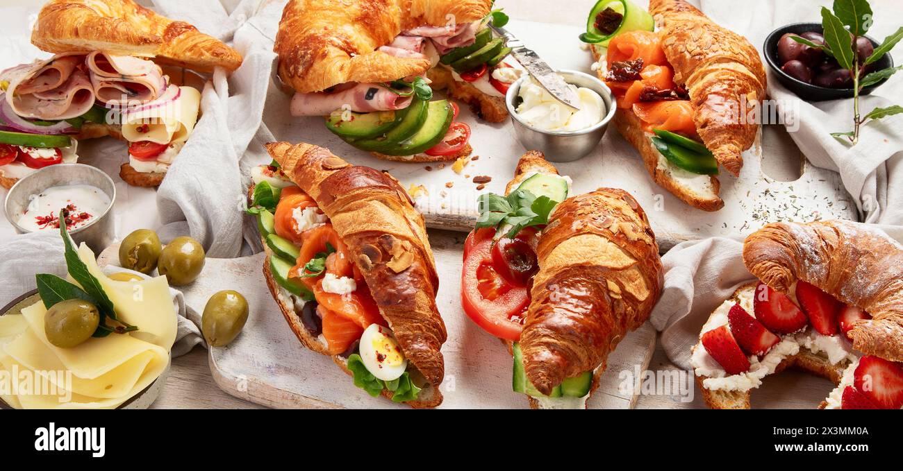 Set of tasty sweet and salty croissant sandwiches on white background ...