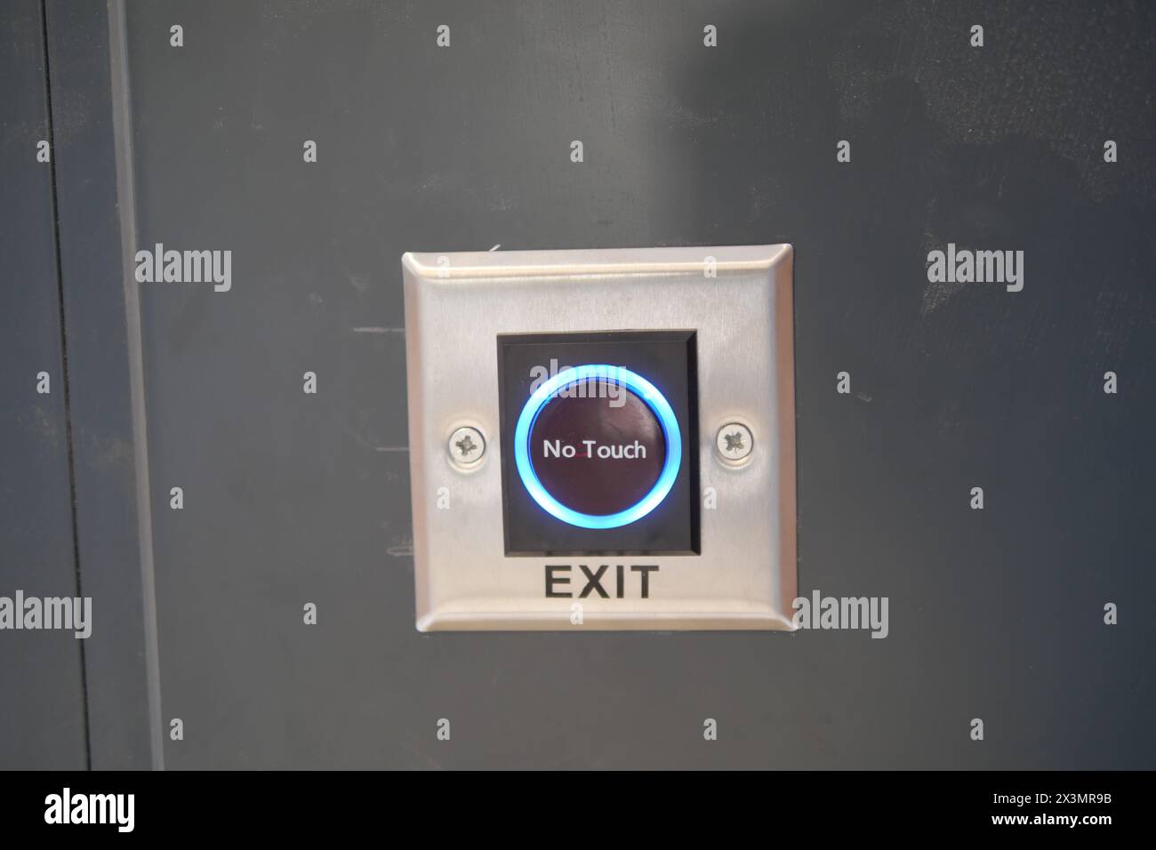 Close up of an exit button on a hardwood door in electric blue font ...