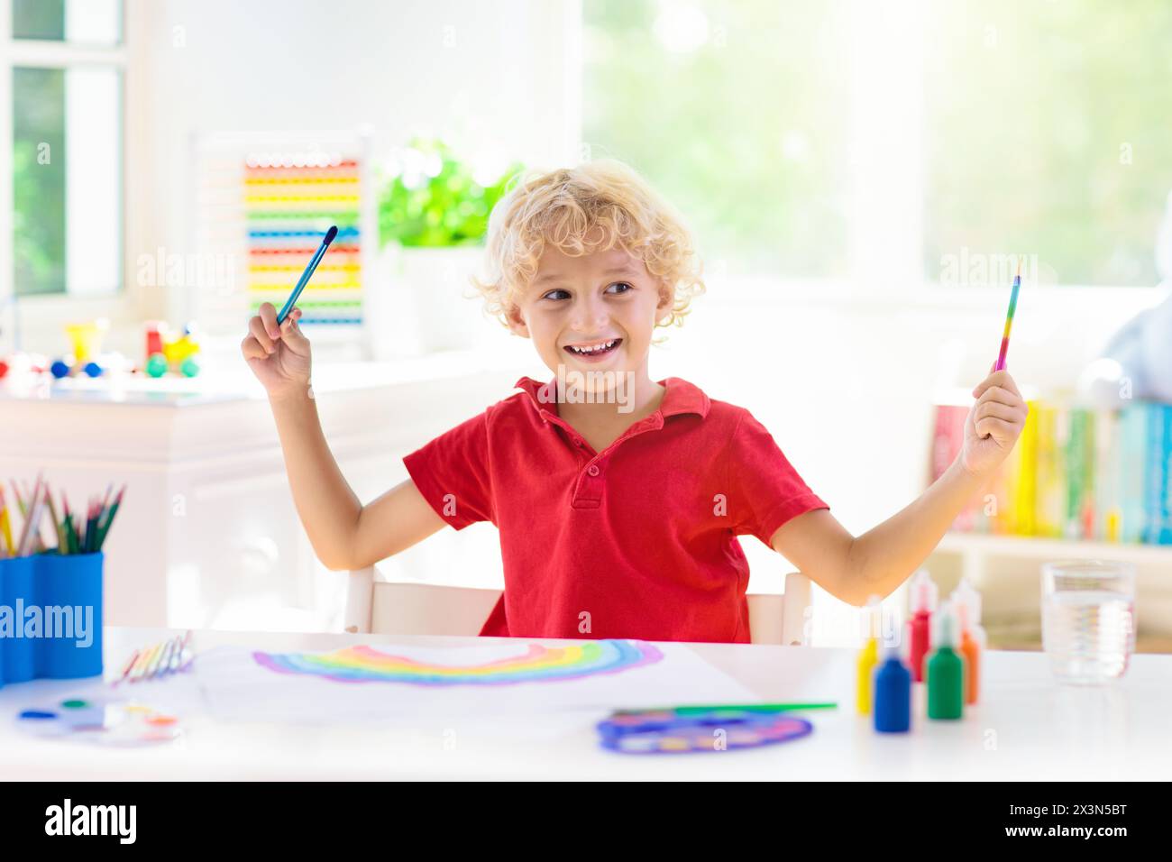 Kids paint. Child painting in white sunny study room. Little boy ...