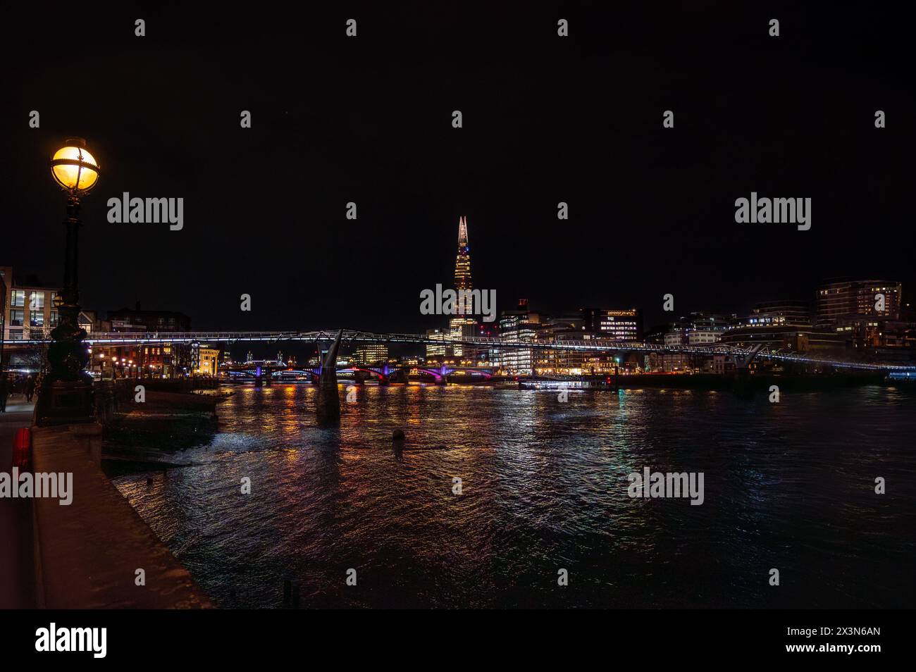 The River Thames illuminated by the reflections of colored lights from ...