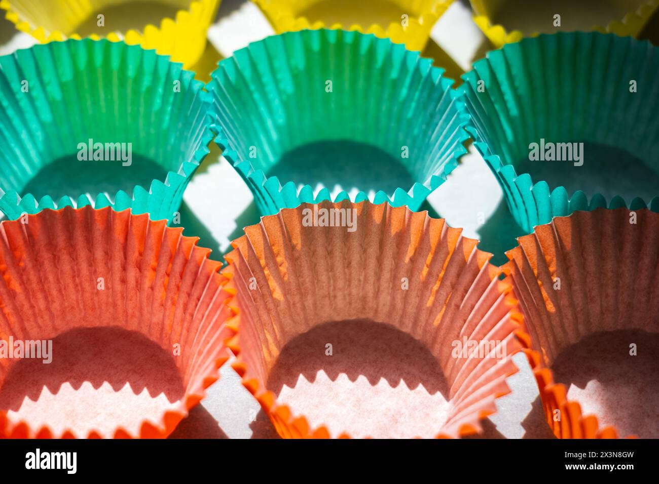 A vibrant display of baking cups in shades of green, light blue, and ...