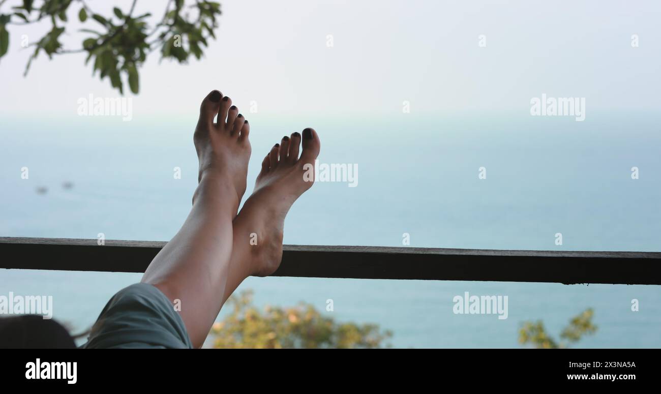 A person laying down with their feet raised up in the air, as if they ...