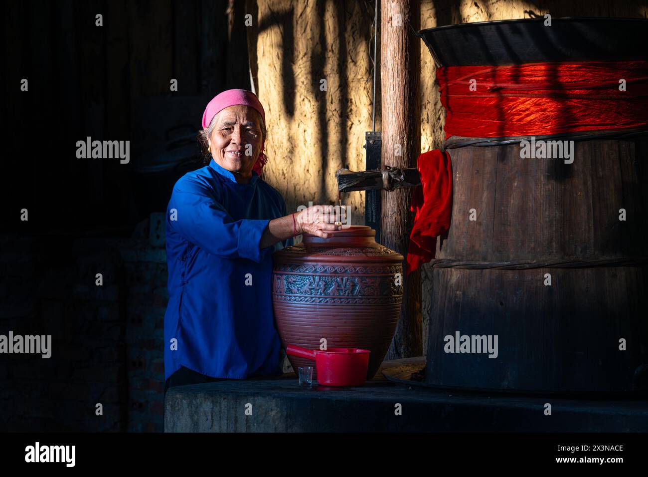 Hmong woman pouring rice wine from a barrel, Bac Ha, Lao Cai Province ...