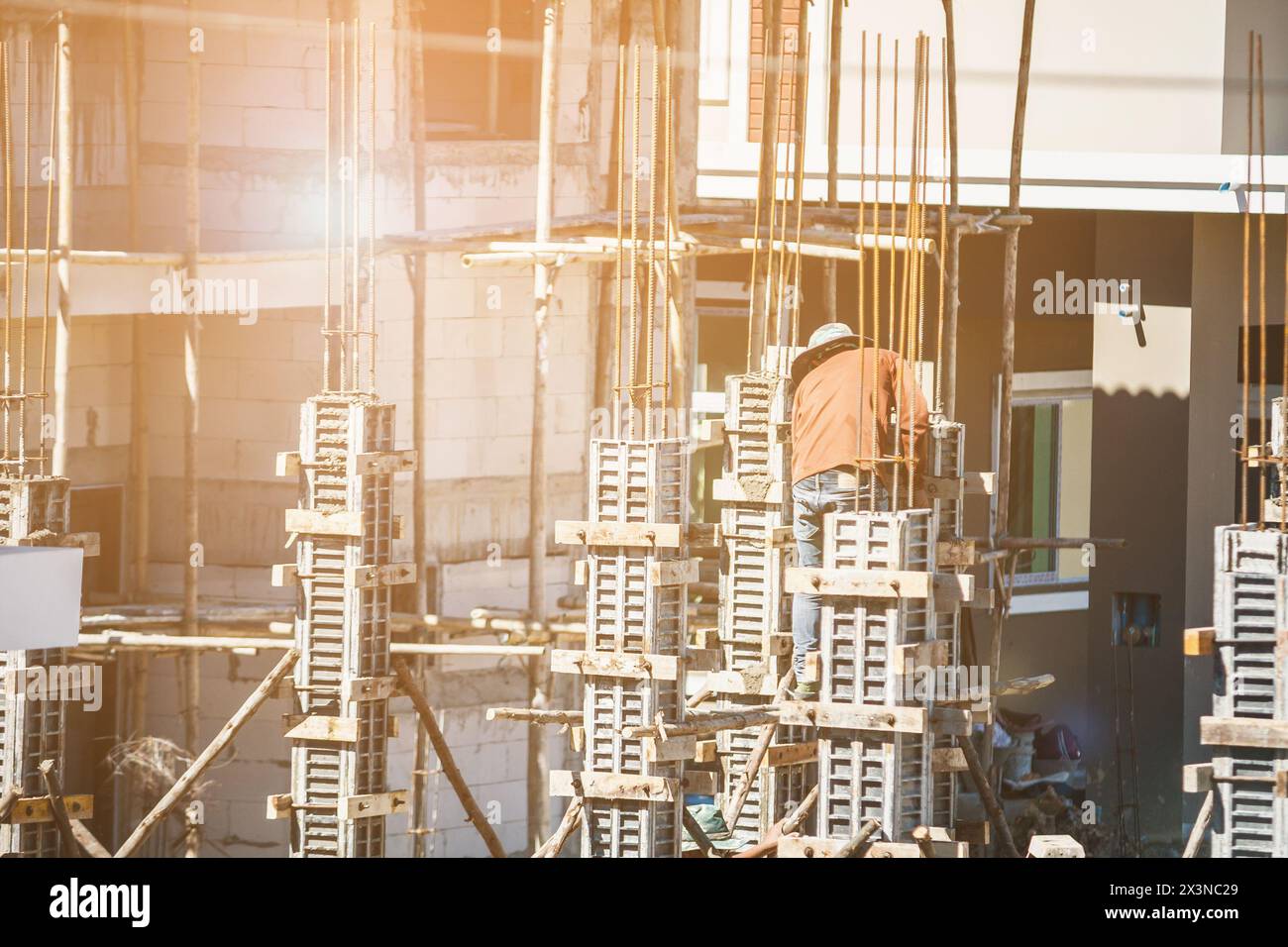 Worker pouring concrete to formwork frames at construction site to ...