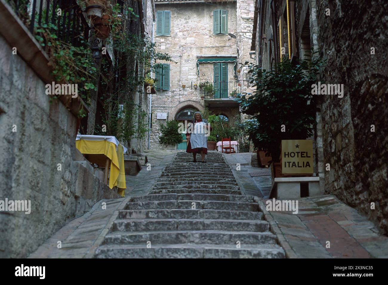 Old lady walking down steps in alley, Assisi, Italy Stock Photo - Alamy