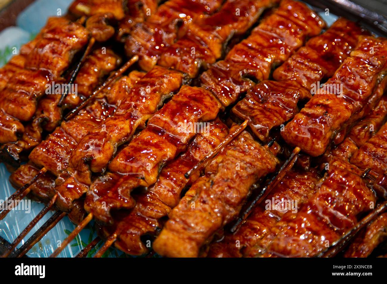 Roasted skewered eel at a food market in the city of Osaka in Japan ...