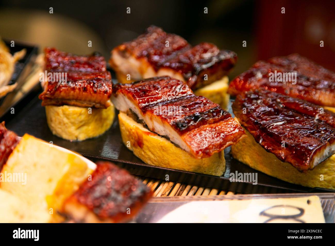 Roasted skewered eel at a food market in the city of Osaka in Japan ...