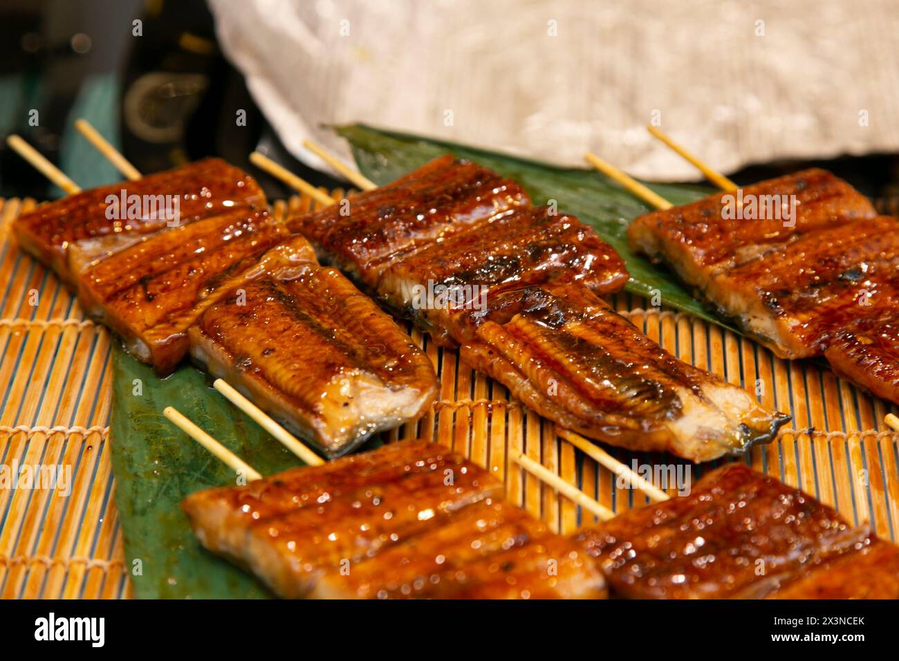 Roasted skewered eel at a food market in the city of Osaka in Japan ...