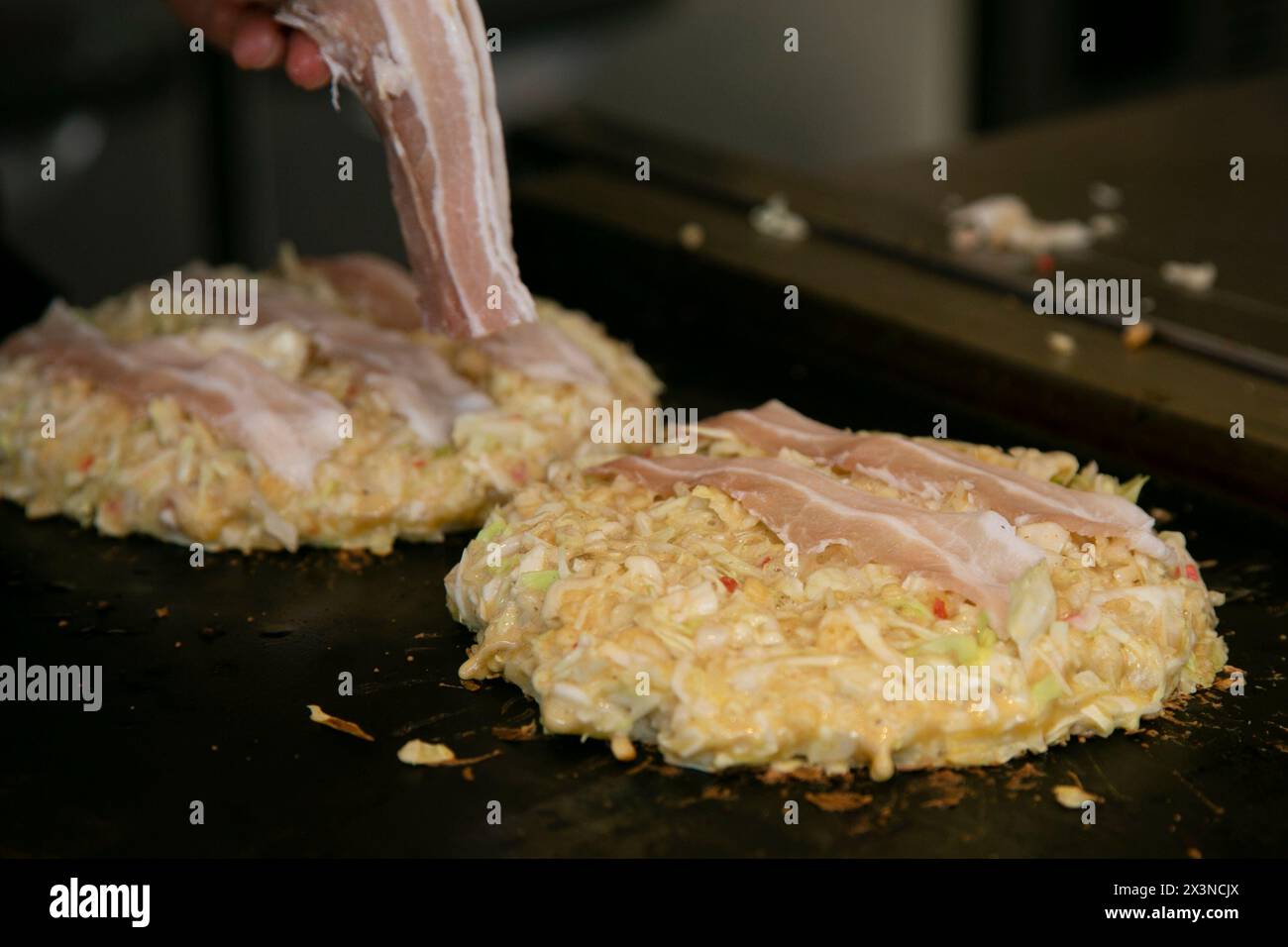 Okonomiyaki is a savory Japanese cabbage pancake “grilled as you like ...