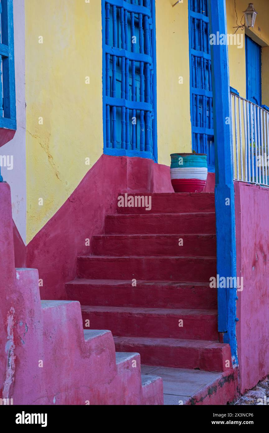 Brightly painted walls and metal grilles over windows of older houses ...