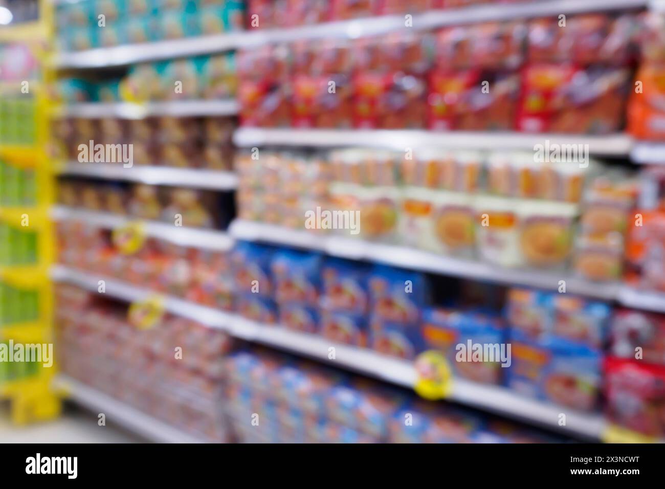 Abstract blur supermarket with variety of fast food snacks chips ...