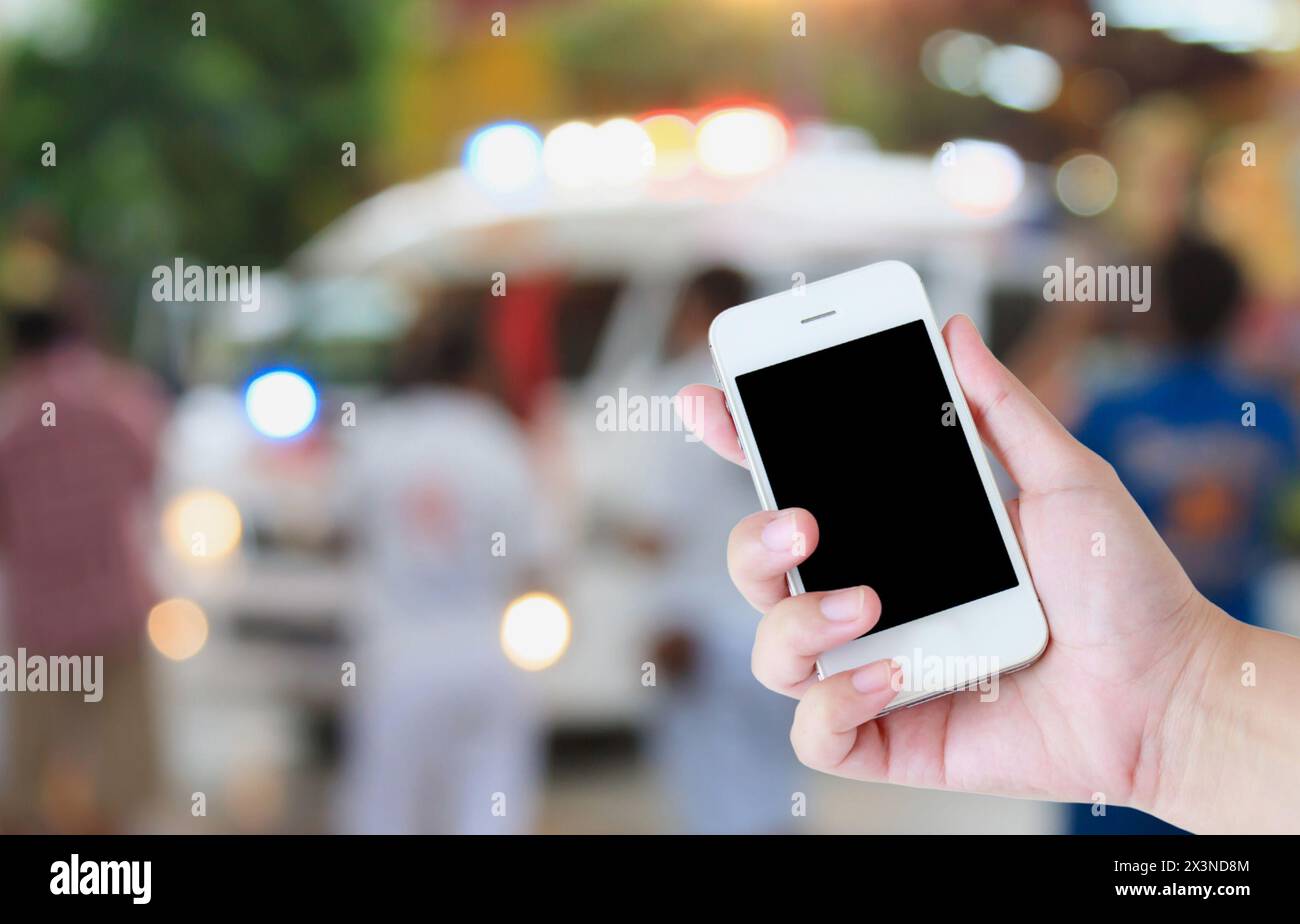 hand hold smartphone with Ambulance responding to an emergency call ...
