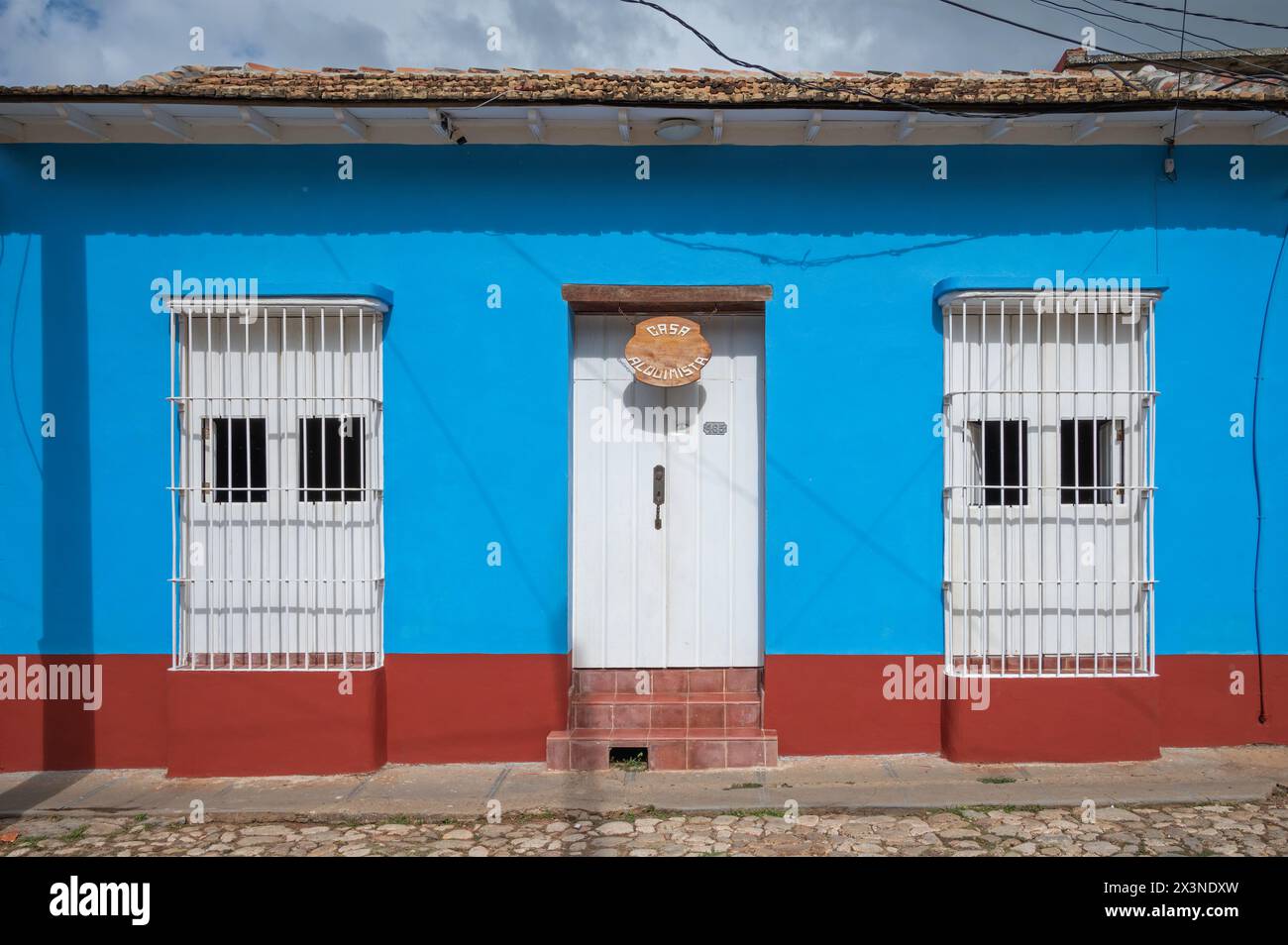 Brightly painted walls and metal grilles over windows of older houses ...