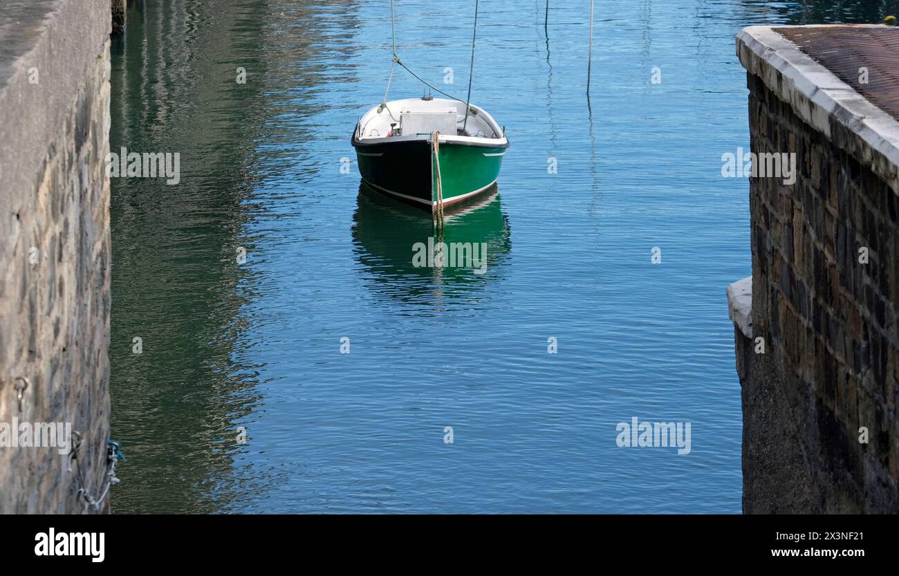 Lone green boat in the calm waters of a harbor Stock Photo - Alamy