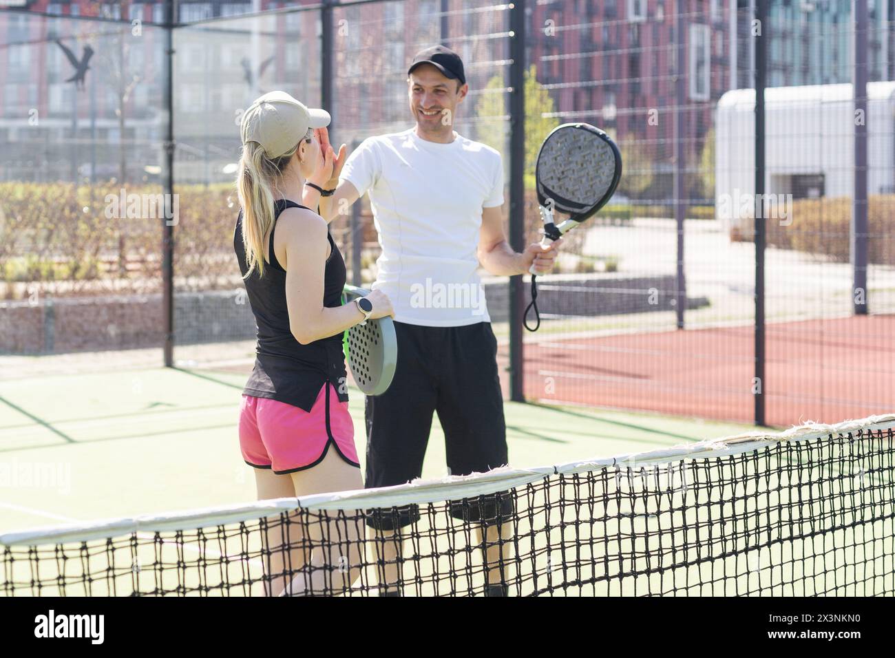 young woman playing Padel Tennis with partner in the open air tennis ...