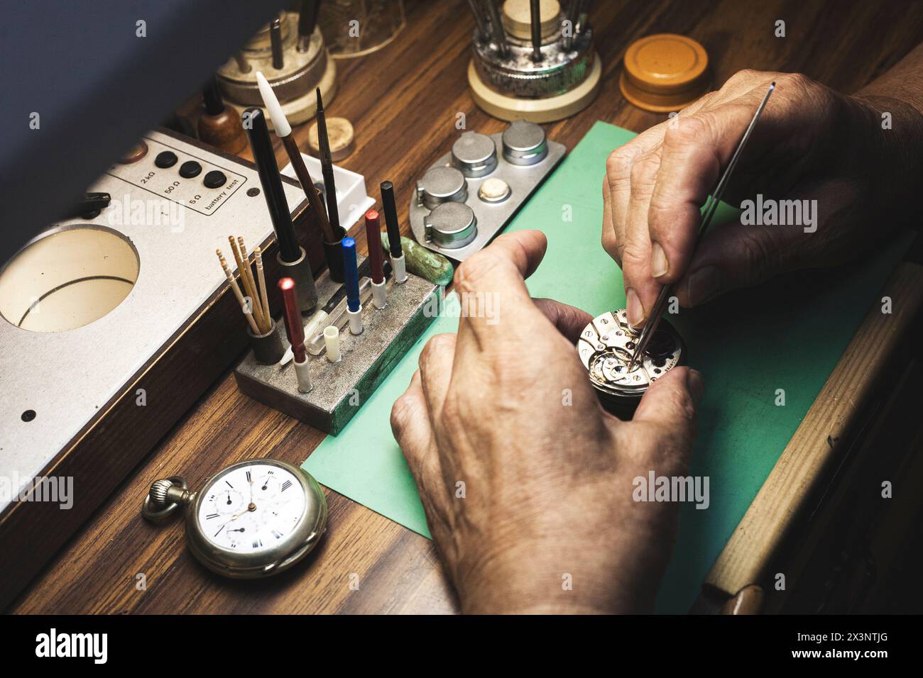 The hands of a watchmaker repairing a watch. They are manipulating a ...
