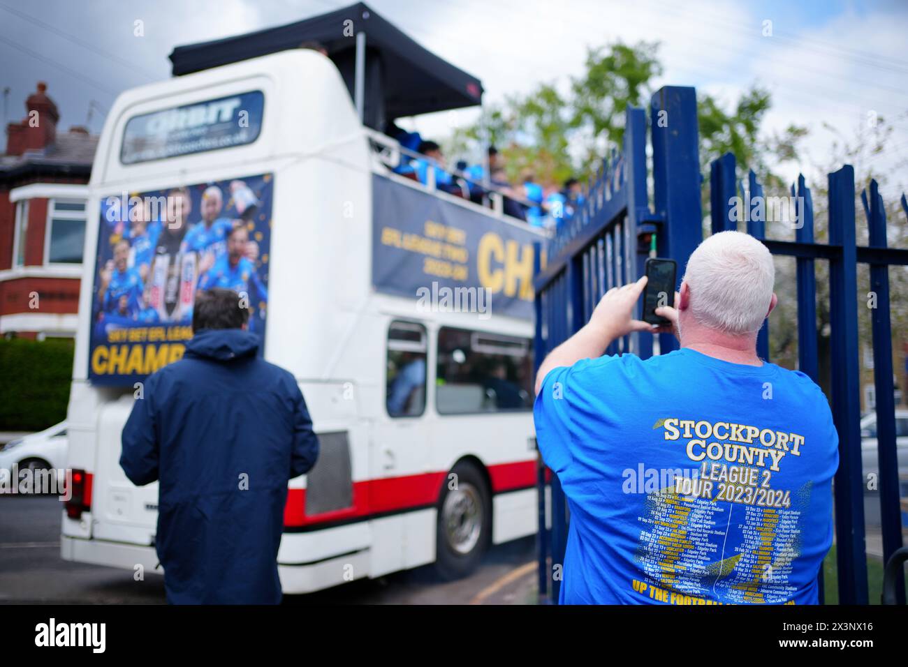 A Stockport County fan takes a photo of the open top-bus outside ...