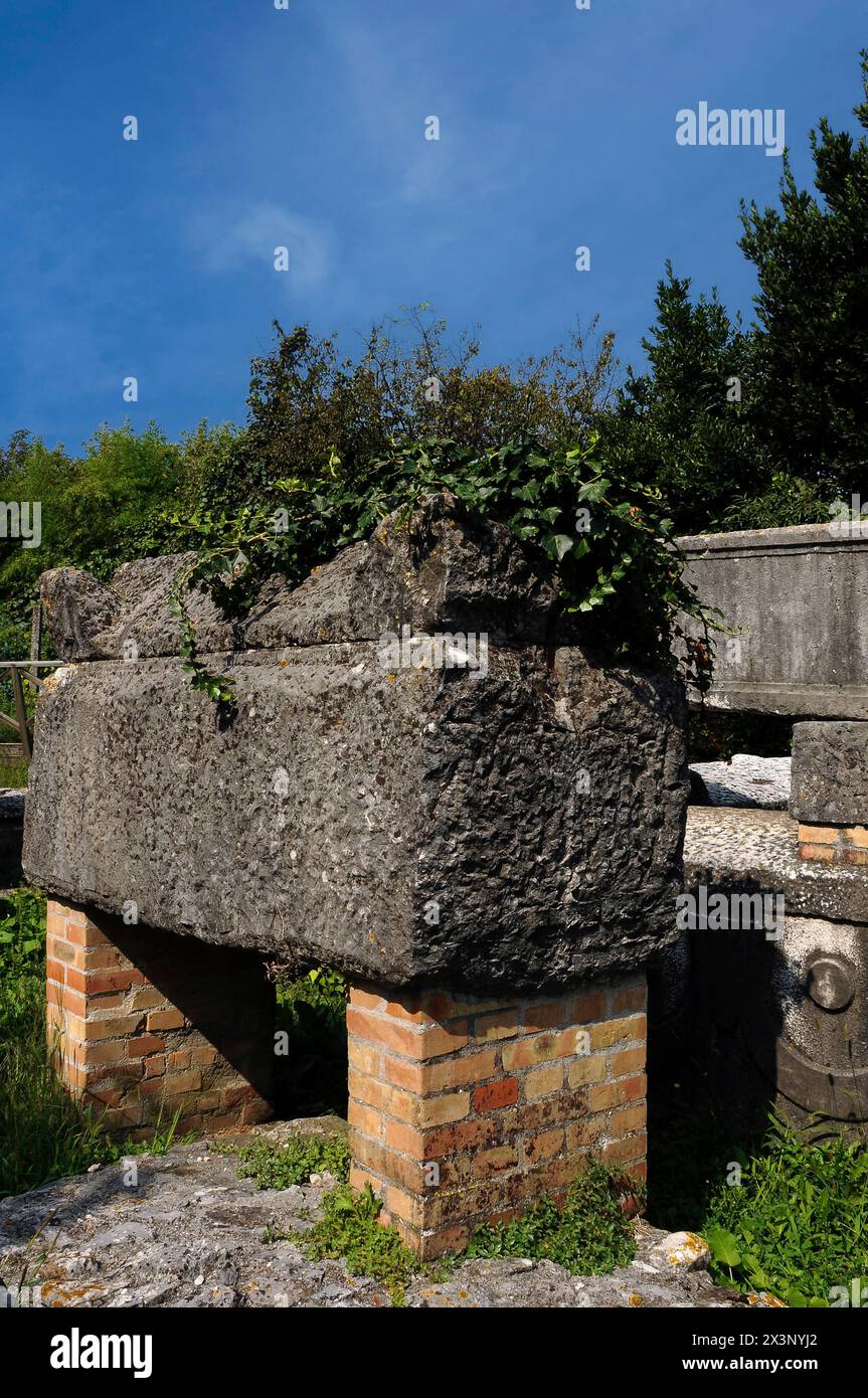 Sarcophagus resting on modern brick pillars. Amid family monuments of ...
