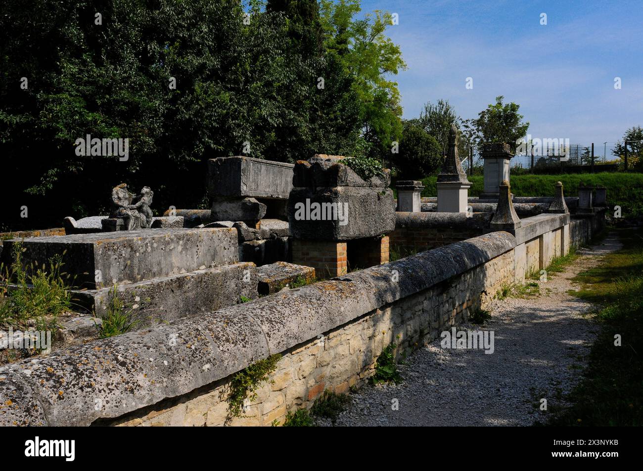 Statue of a woman, now headless, and child embracing amid tombs ...