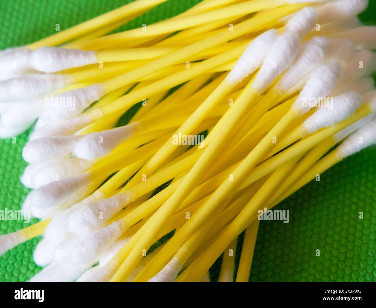 Hygiene Essentials. Yellow cotton swabs on a green surface Stock Photo ...