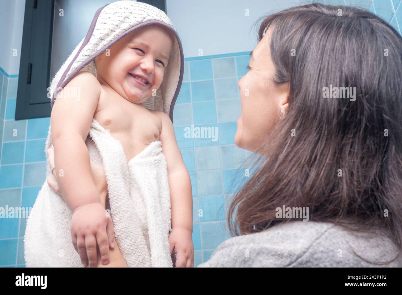 Mother picks up her towel-wrapped son after a shower Stock Photo - Alamy