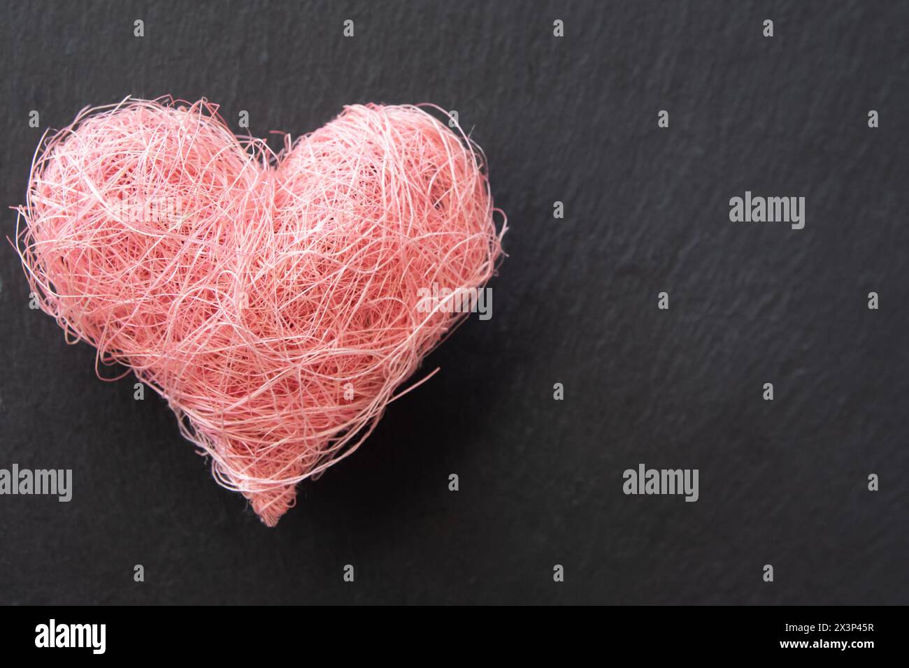 Heart shape made of material fabric on the black background with ...