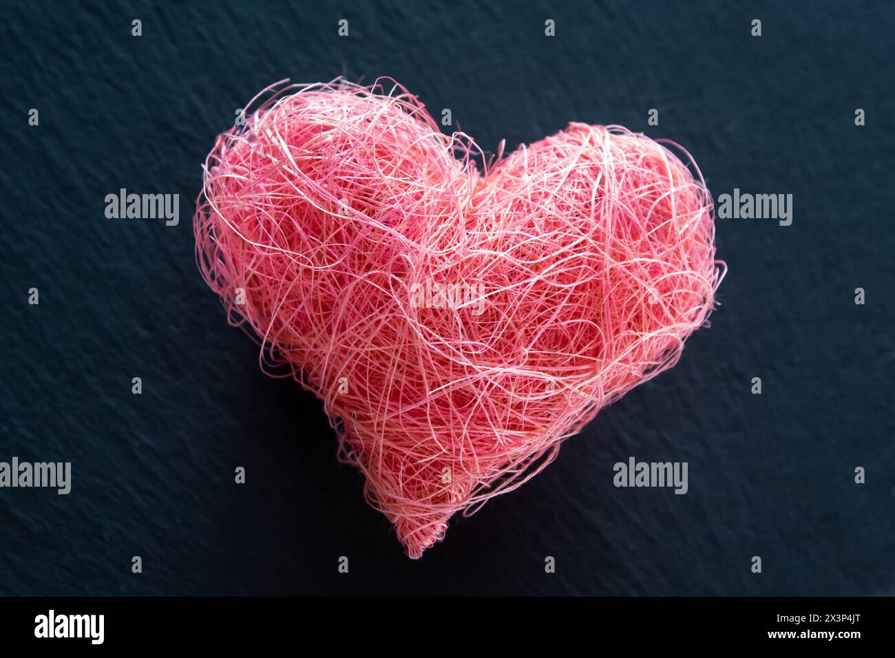 Heart shape made of material fabric on the black background with ...