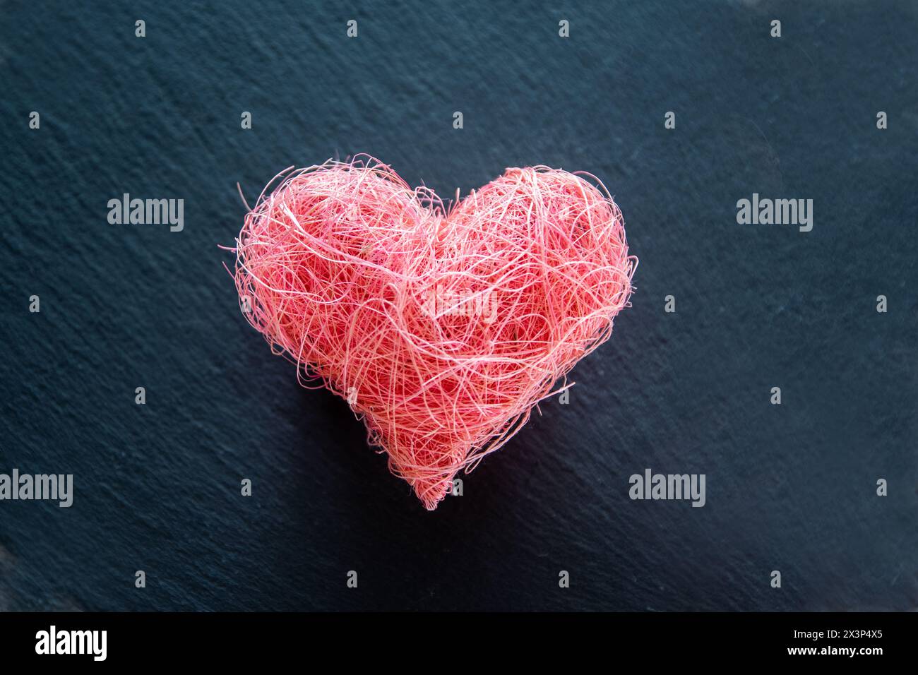 Heart shape made of material fabric on the black background with ...