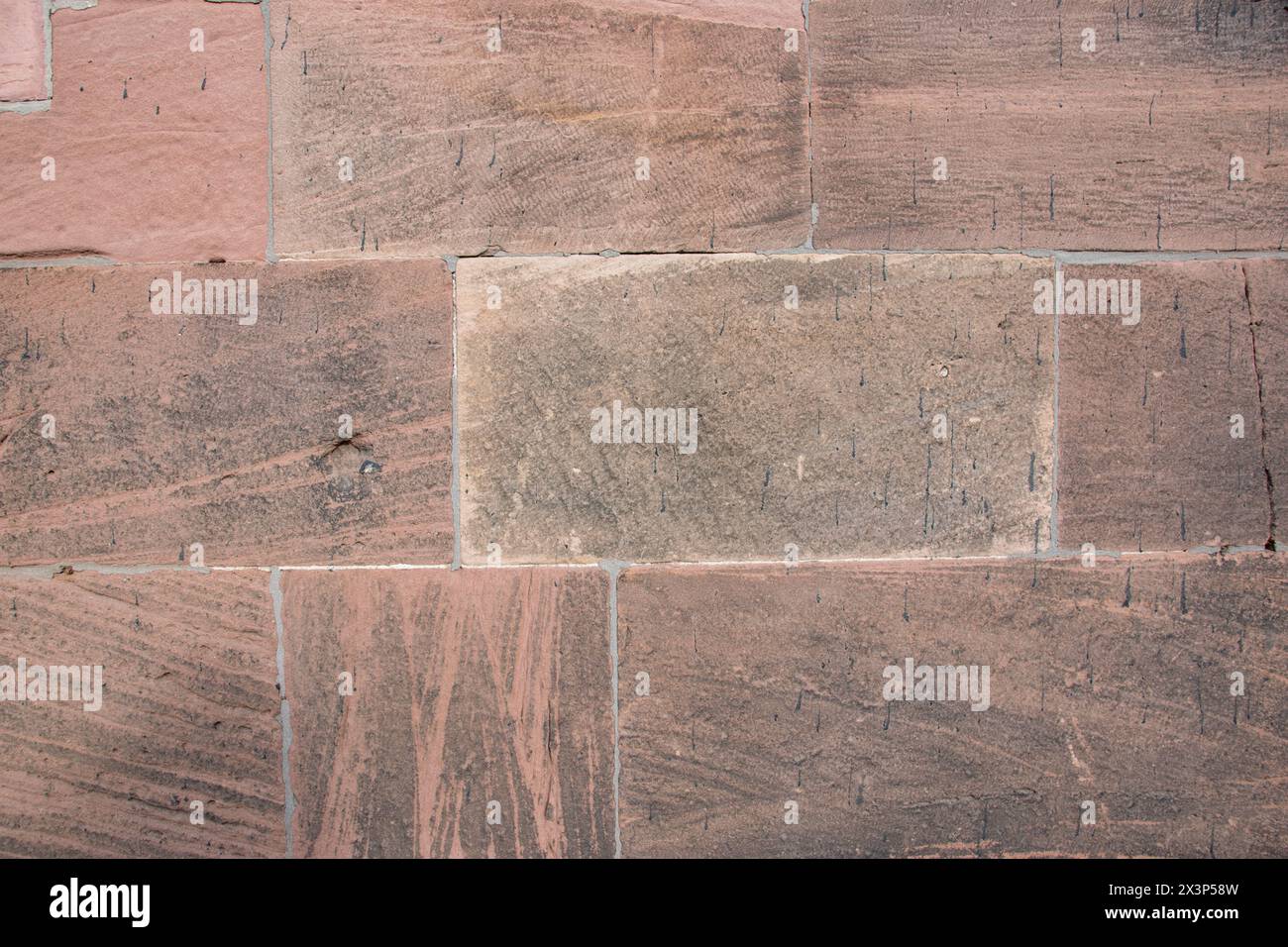 Structural stone wall of the ancient building consists of red big old ...