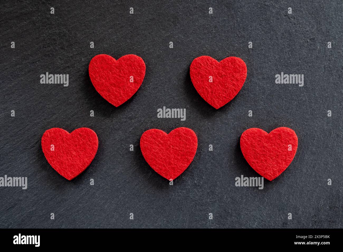 Red hearts made of material fabric on the black stone background ...