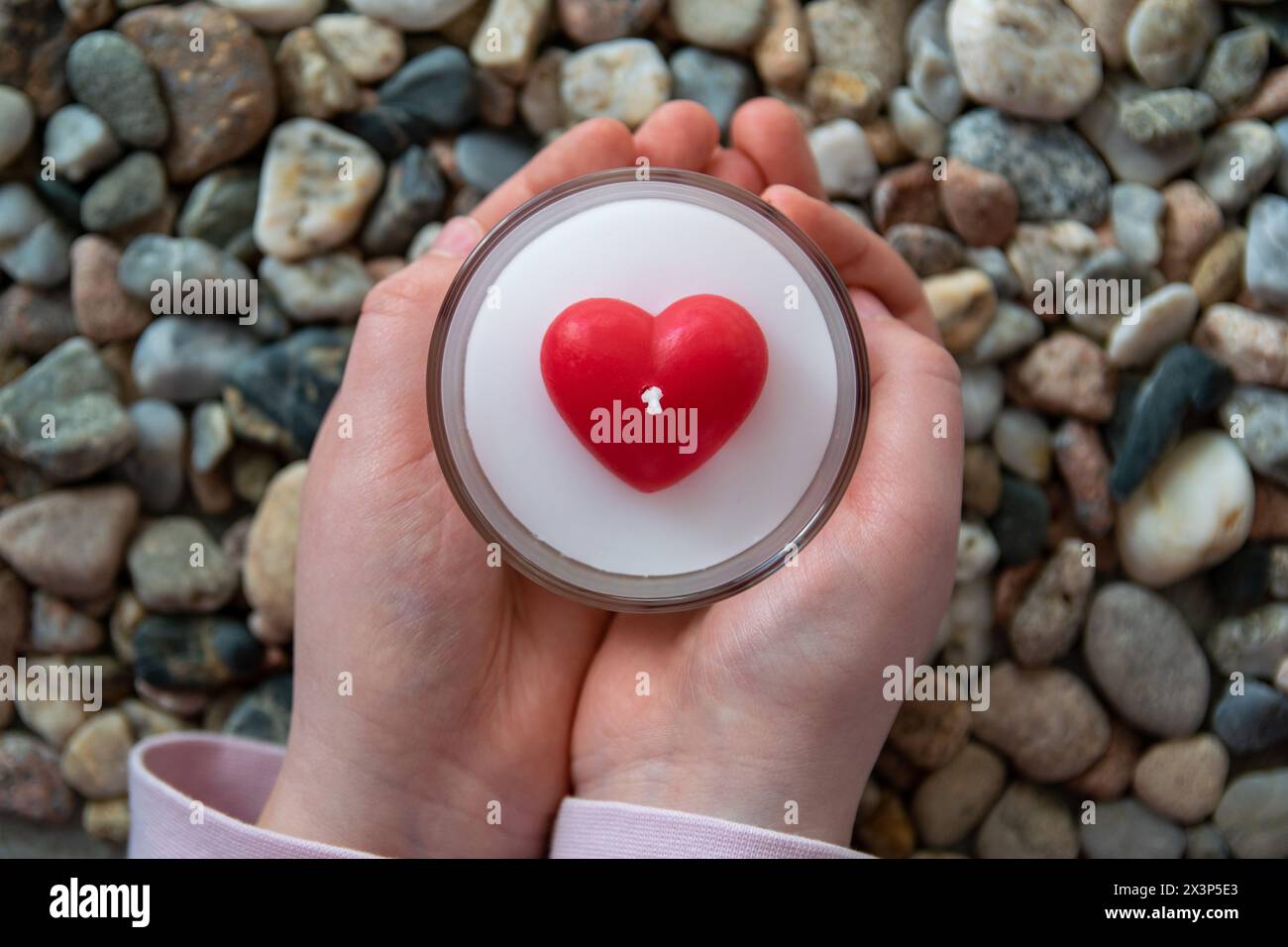 Red heart handle in child hands on the stones background. Concept of ...