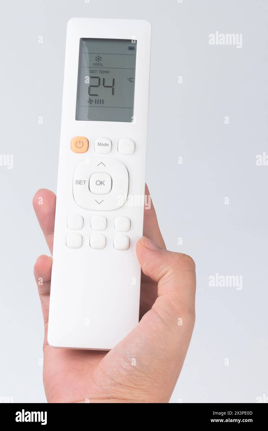 Climate remote control with screen in hand isolated on white studio ...