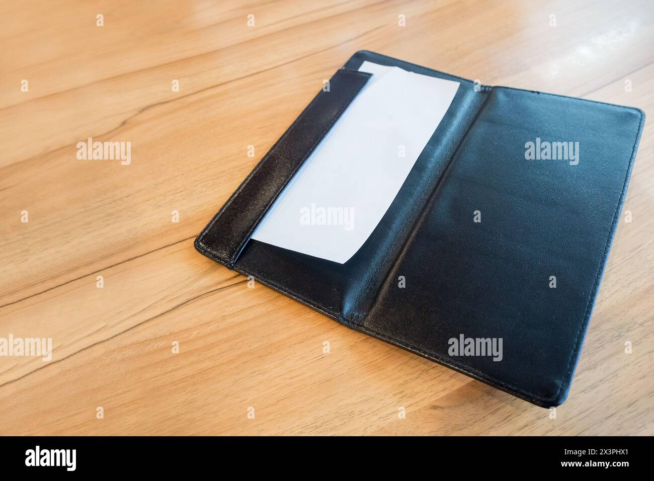 Blank empty white paper in black leather restaurant payment billing ...