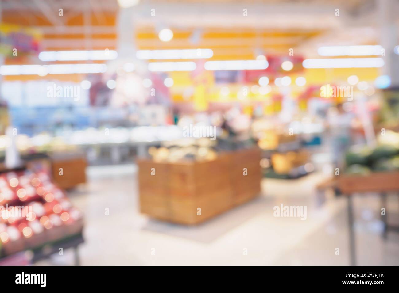 Supermarket with fresh fruits and vegetable on shelves in store blurred ...