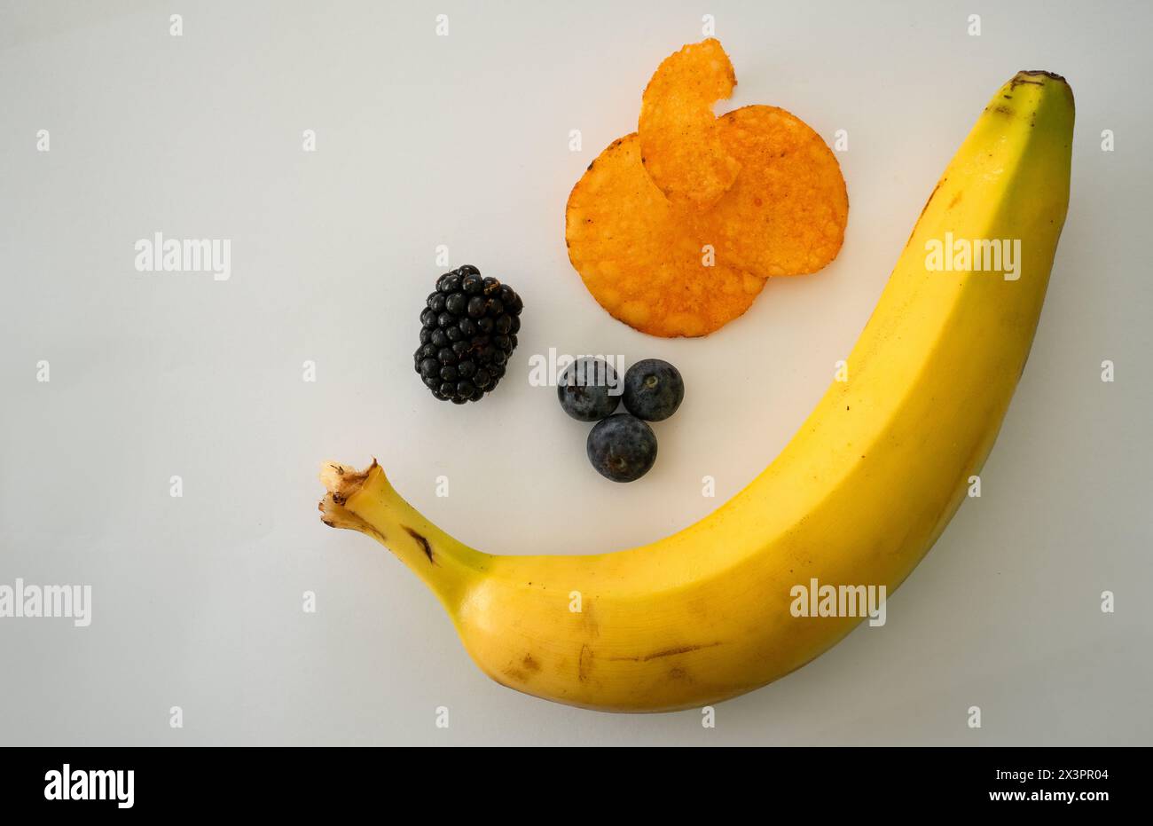 Assortment of a banana, a blackberry, three blueberries, and some ...