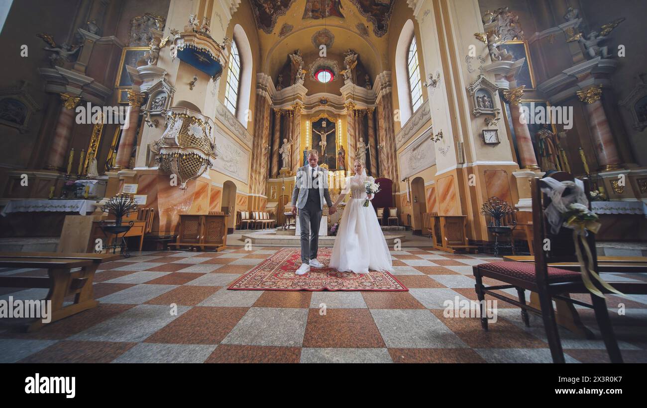 The bride and groom walk through a Catholic church Stock Photo - Alamy