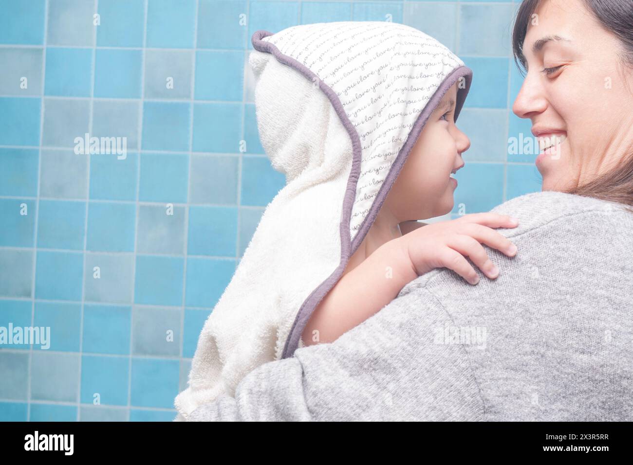 Smiling mother and son look at each other with great complicity as the ...